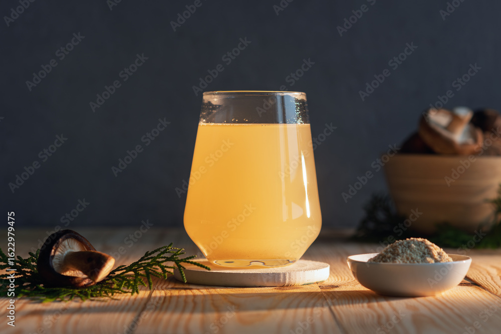 Golden adaptogenic mushroom elixir glows in a modern glass on rustic ...