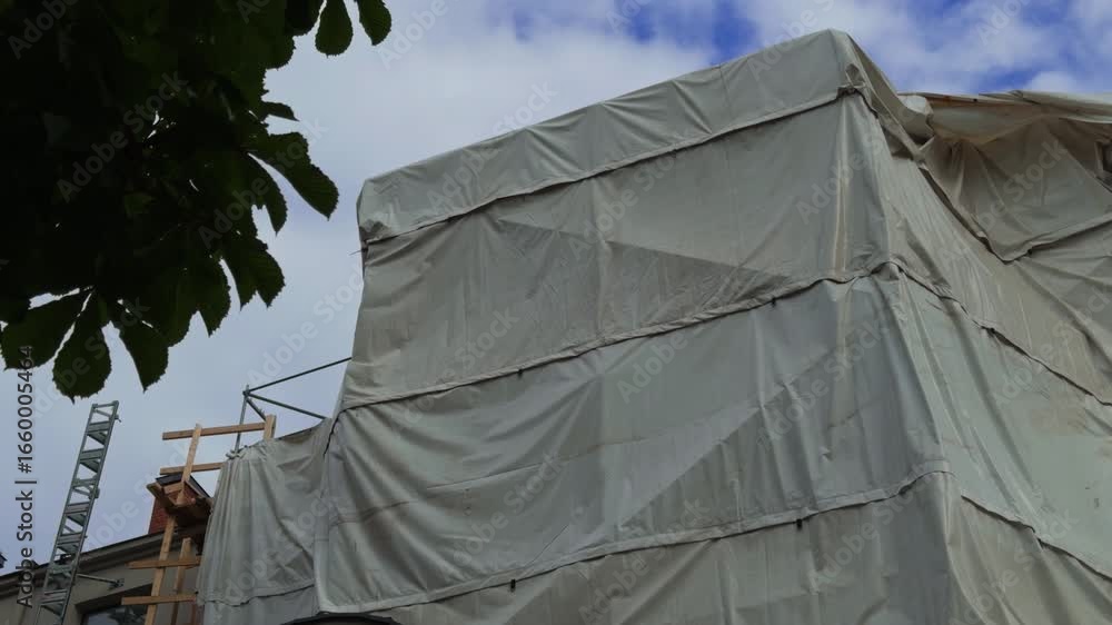 Construction Site Featuring Scaffolding and Tarps That Are Covering a ...