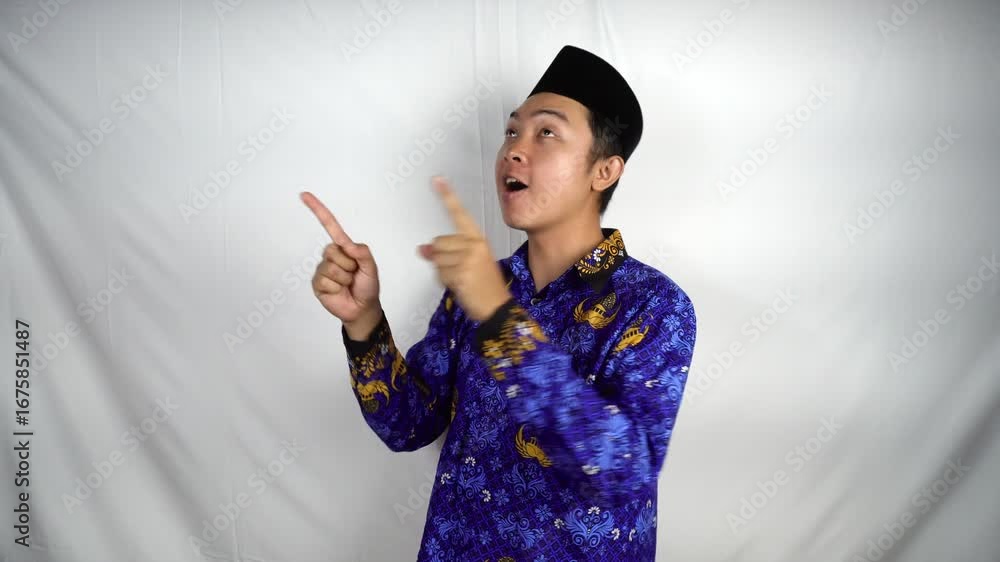 An Indonesian male civil servant wearing a blue Korpri batik uniform ...