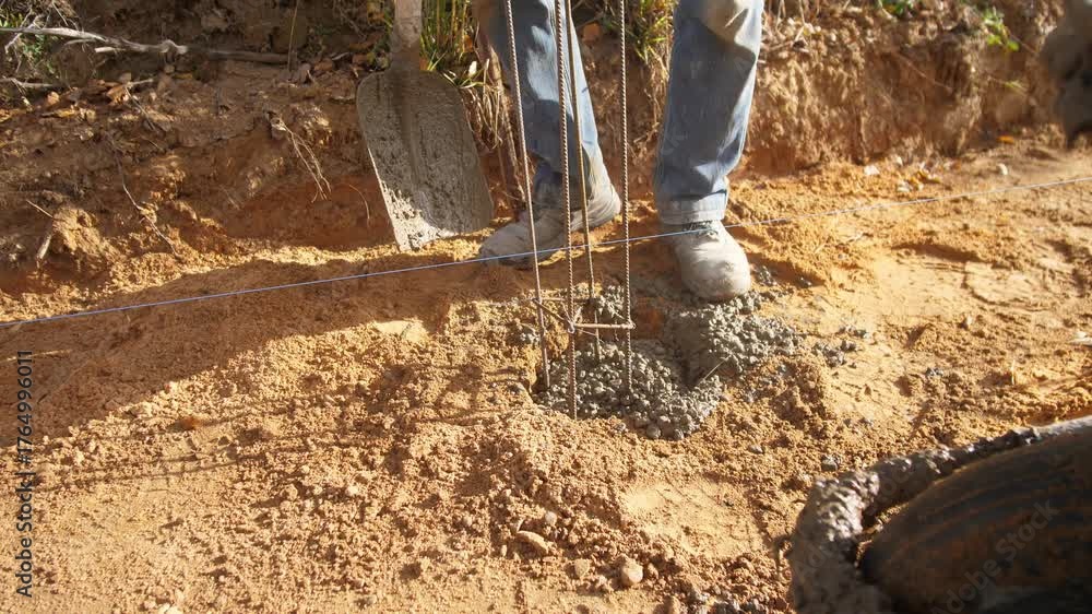 Vidéo Stock concrete rebar footing, shoveling fresh concrete into rebar ...