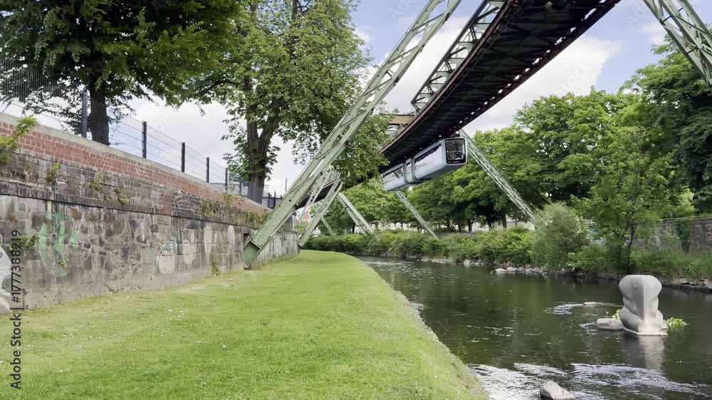 Schwebebahn suspended monorail train passing overhead River Wupper and ...