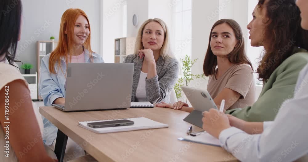 Women group meeting around office table to discuss business tasks and ...
