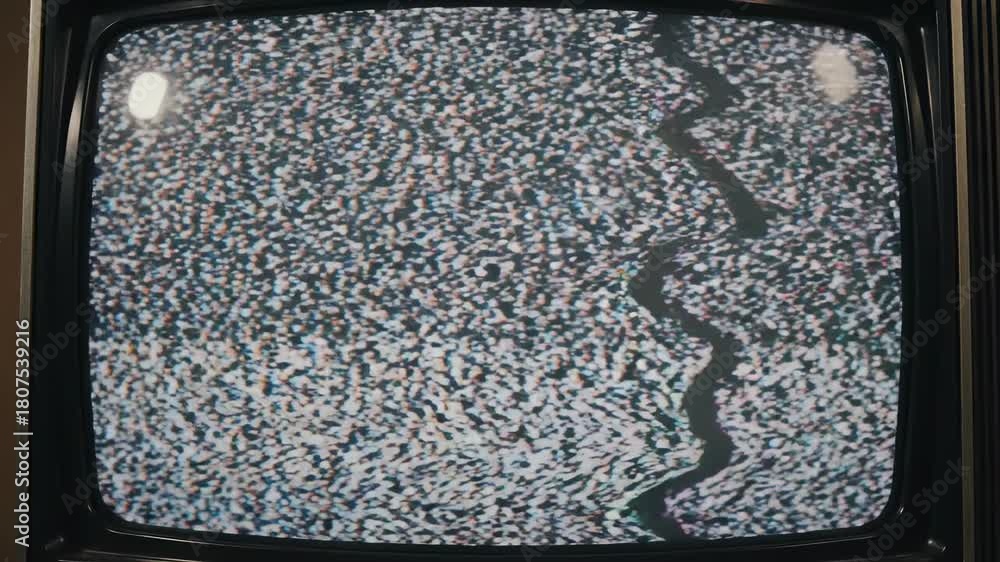 Static's grip and Crack in the screen: The television screen is filled ...