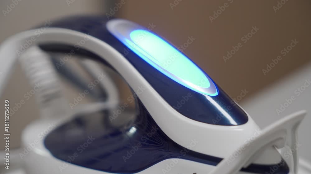 The plastic body of a modern steam iron is shown as its indicator light ...
