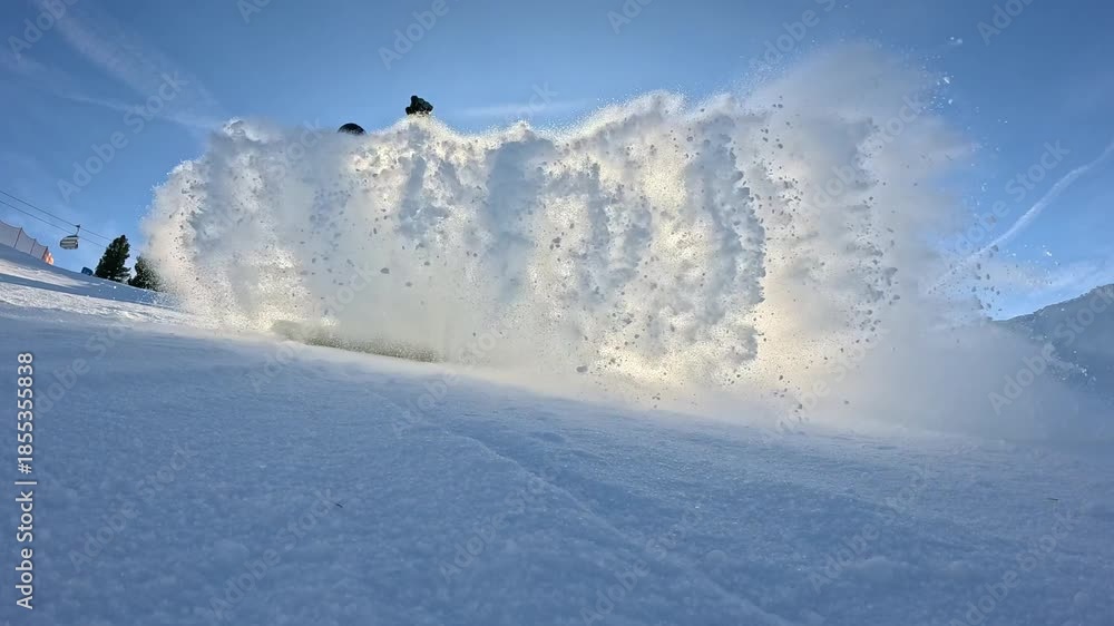 LENS FLARE, LOW ANGLE VIEW, SLOW MOTION: Snowboarder sends a cloud of ...