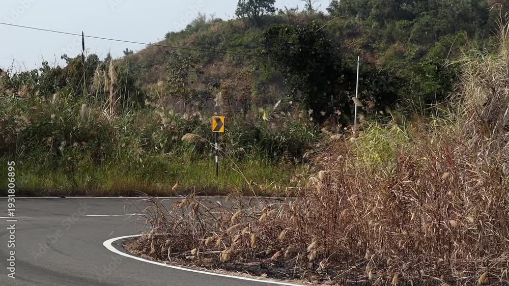 Winding Mountain Road With Curve Sign and Dry Grass Stock ビデオ | Adobe Stock