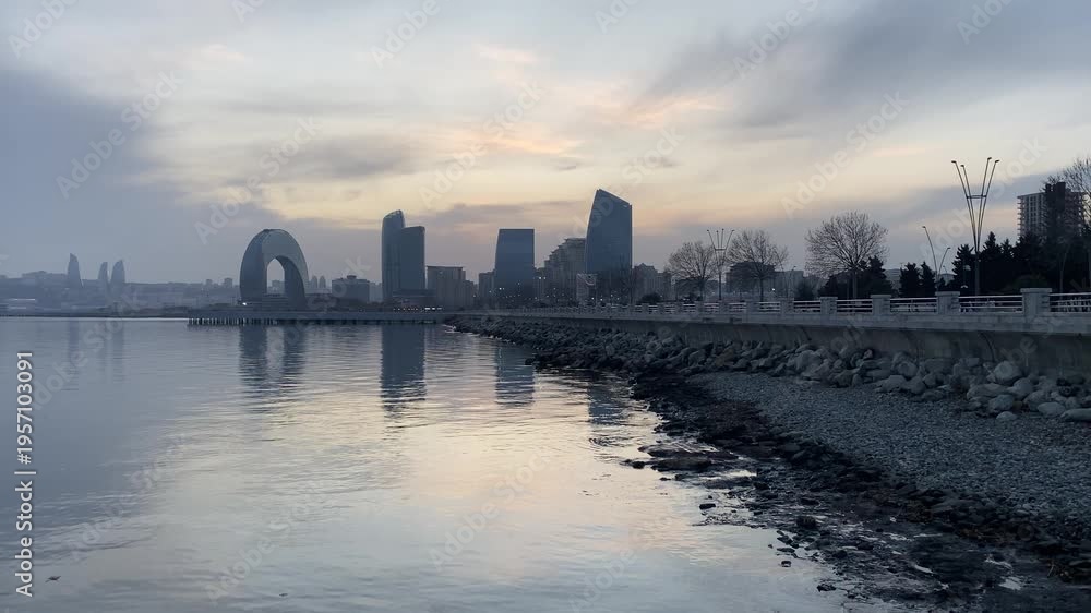 Sunset view of Baku skyline by the sea with modern buildings and calm ...